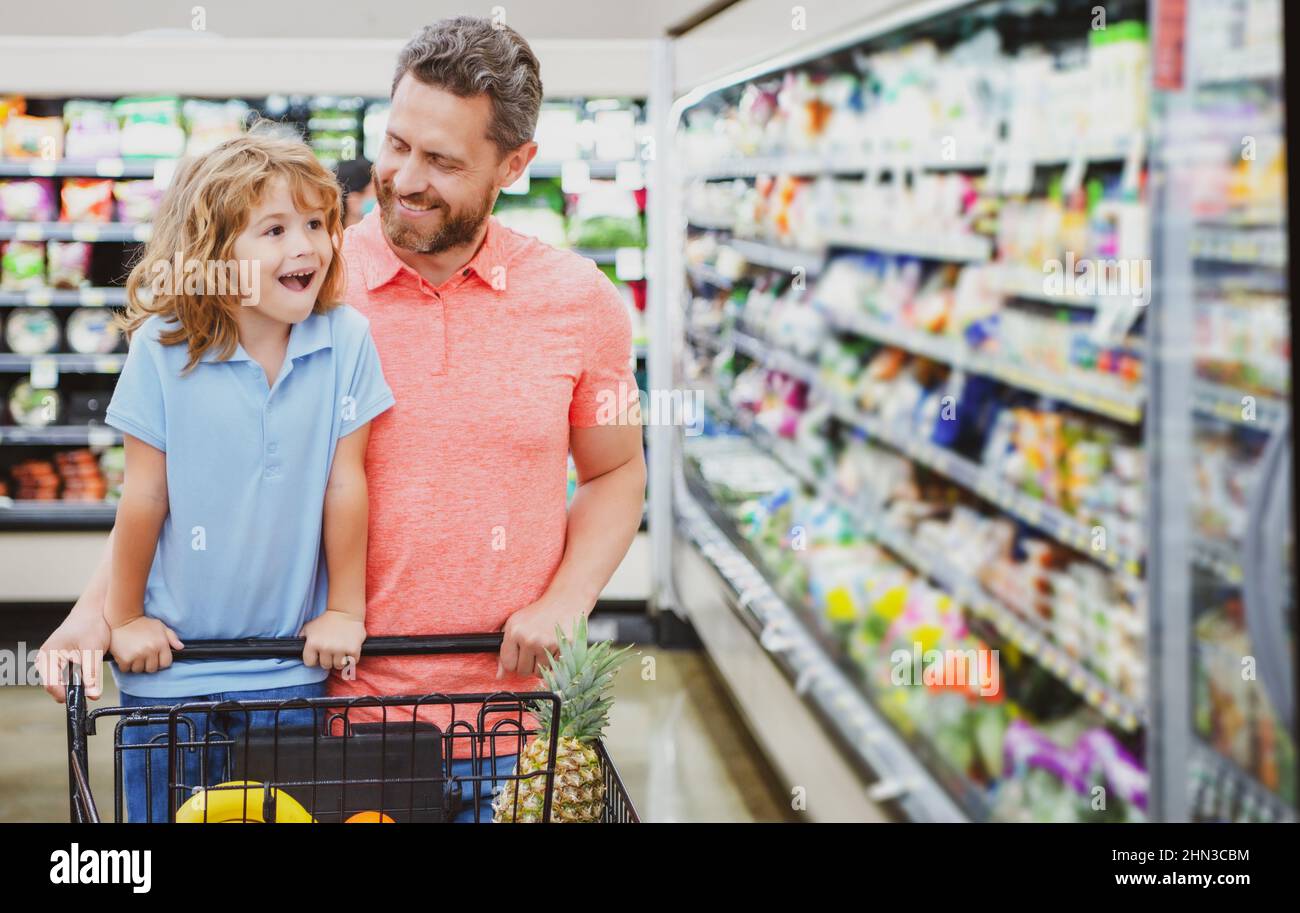 Father and son looking at product at grocery store. Dad with child in ...