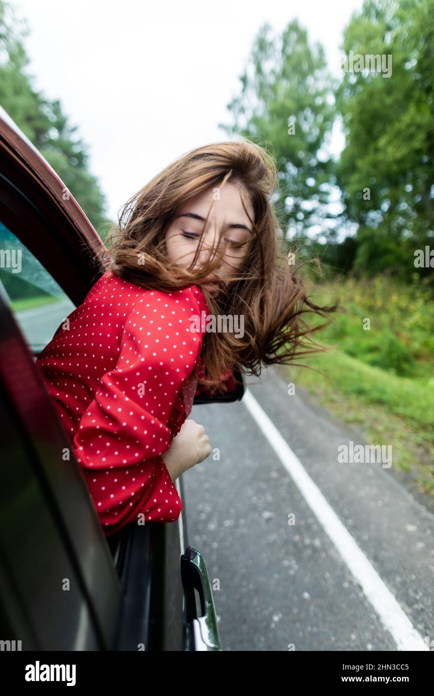 A girl in a light red airy dress, a leather jacket in a rockstyle on an ...