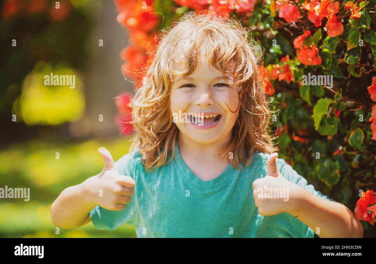 Portrait of a happy laughing child. Close up positive kids face, thumbs ...