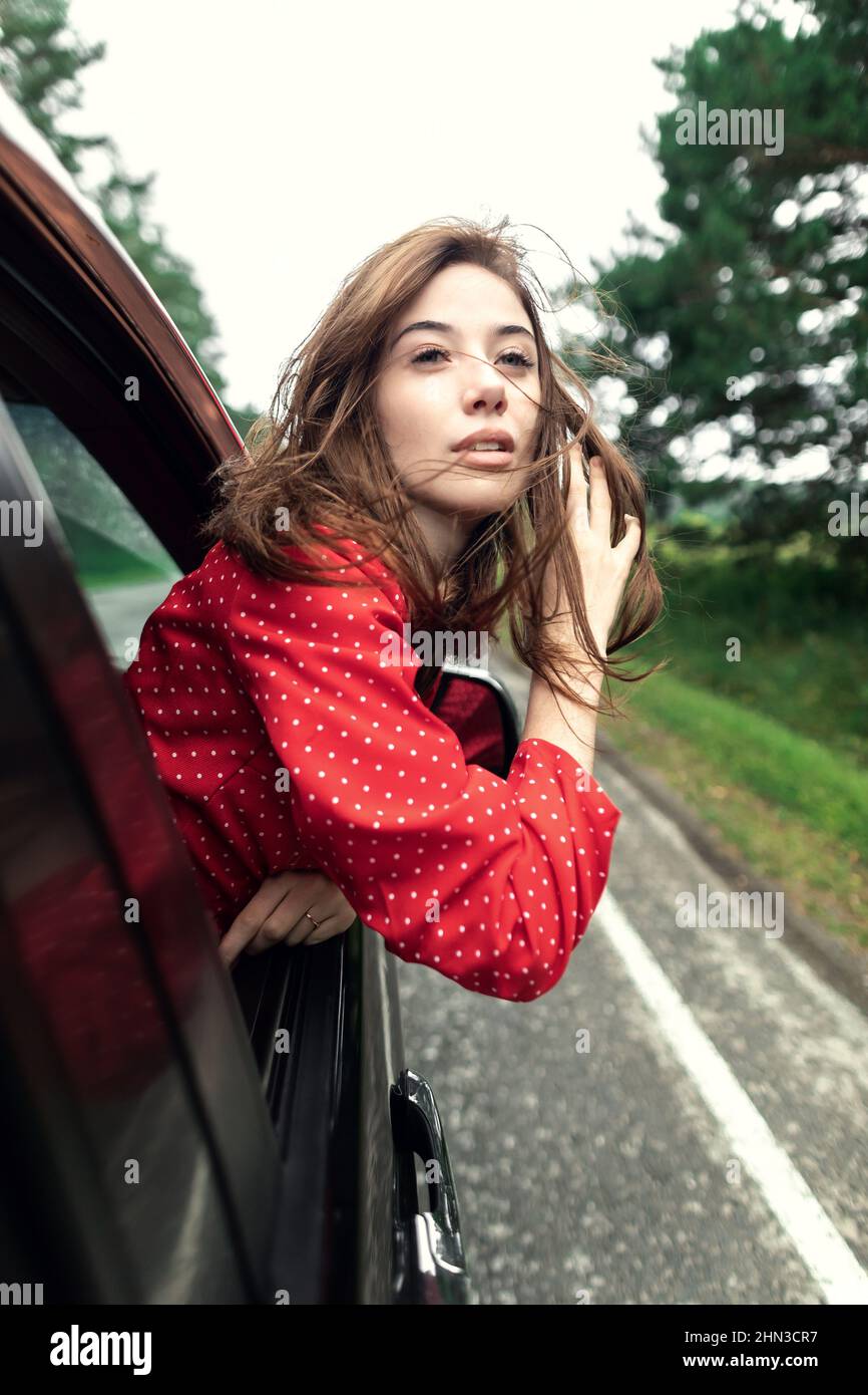 A girl in a light red airy dress, a leather jacket in a rockstyle on an ...