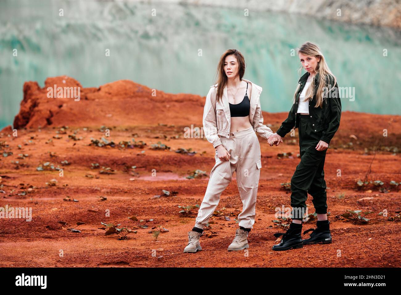 Girls in a post-apocalyptic place, a quarry with red earth and stones ...