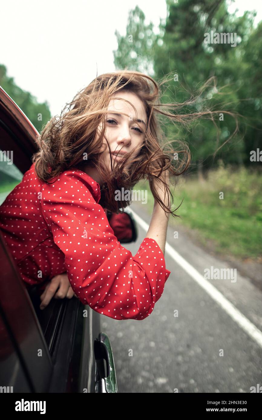 A girl in a light red airy dress, a leather jacket in a rockstyle on an ...