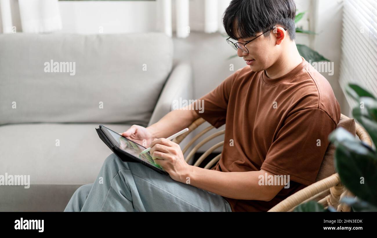 Technology Concept The young man who is sitting on the chair holding ...
