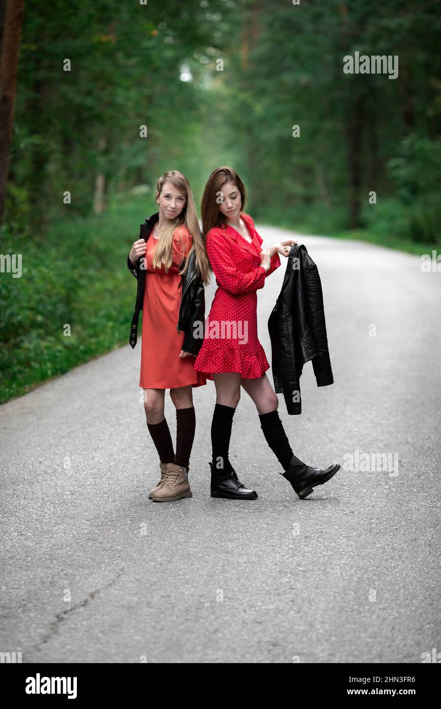 A girl in a light red airy dress, a leather jacket in a rockstyle on an ...
