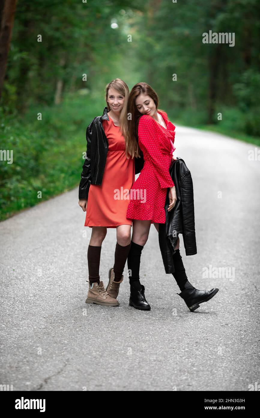 A girl in a light red airy dress, a leather jacket in a rockstyle on an ...