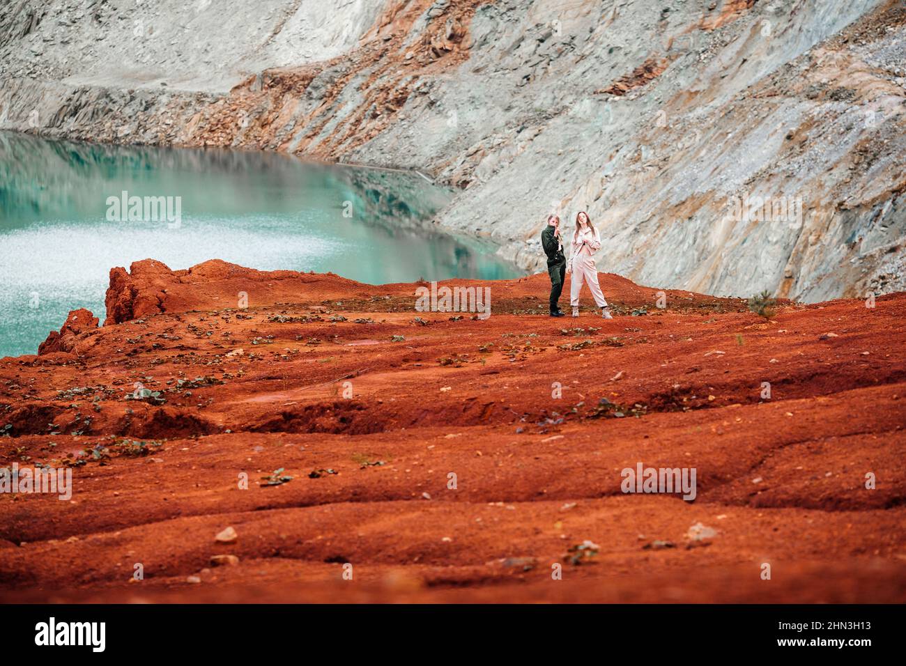 Girls in a post-apocalyptic place, a quarry with red earth and stones ...