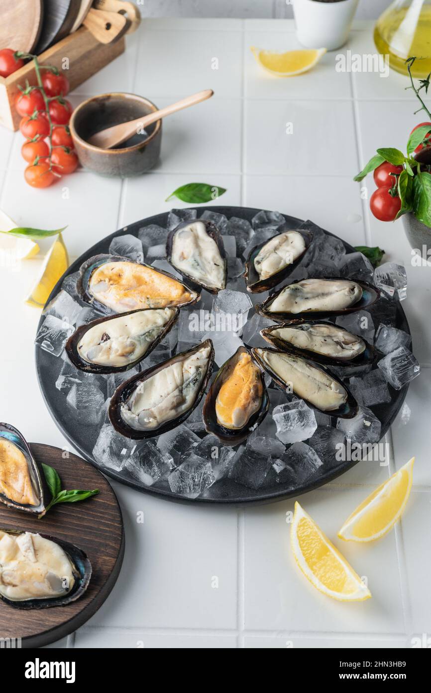 selective focus. raw mussels in the sink spread out on ice on a plate ...