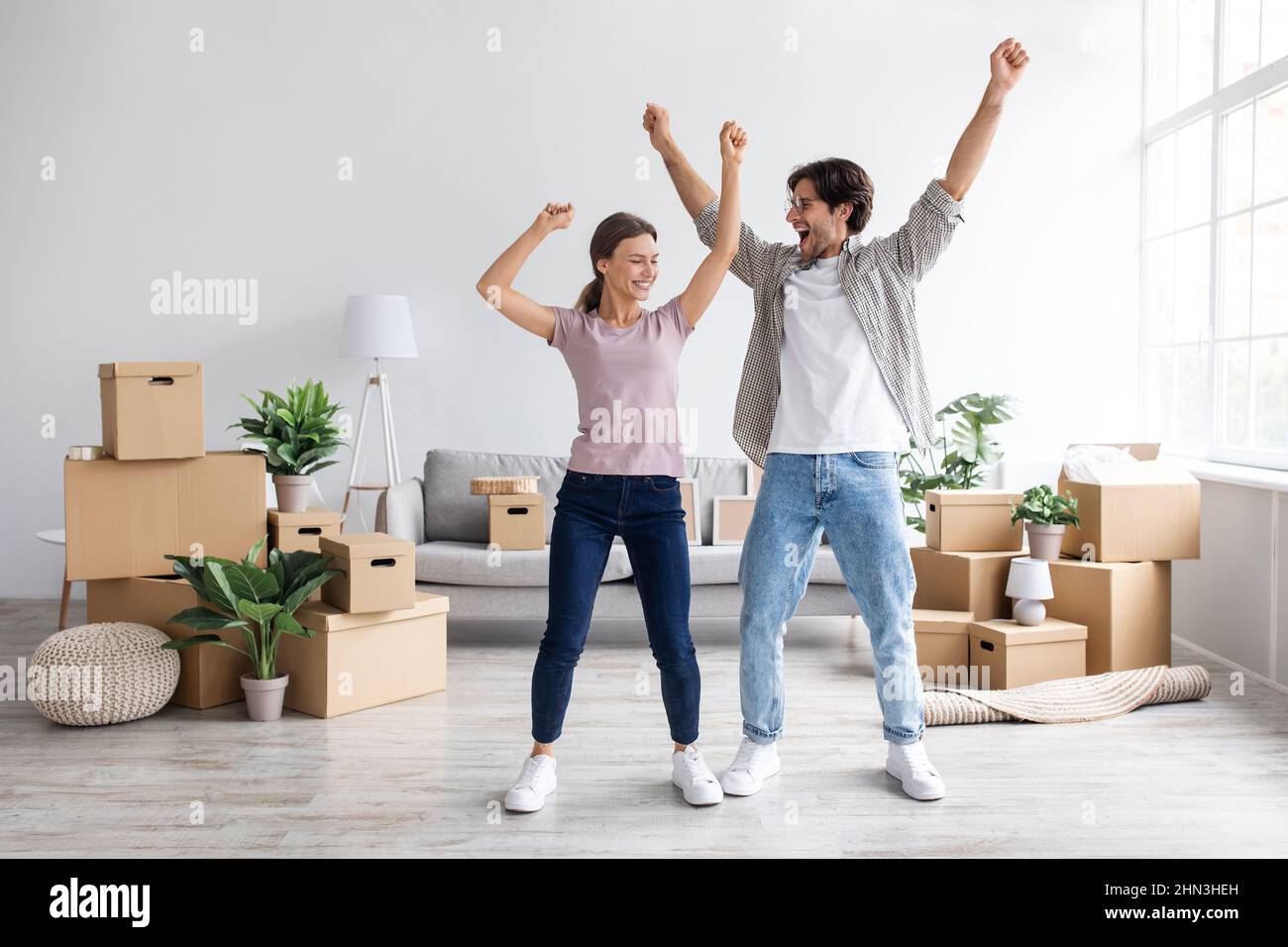 Satisfied european millennial guy and woman have fun dancing in room ...