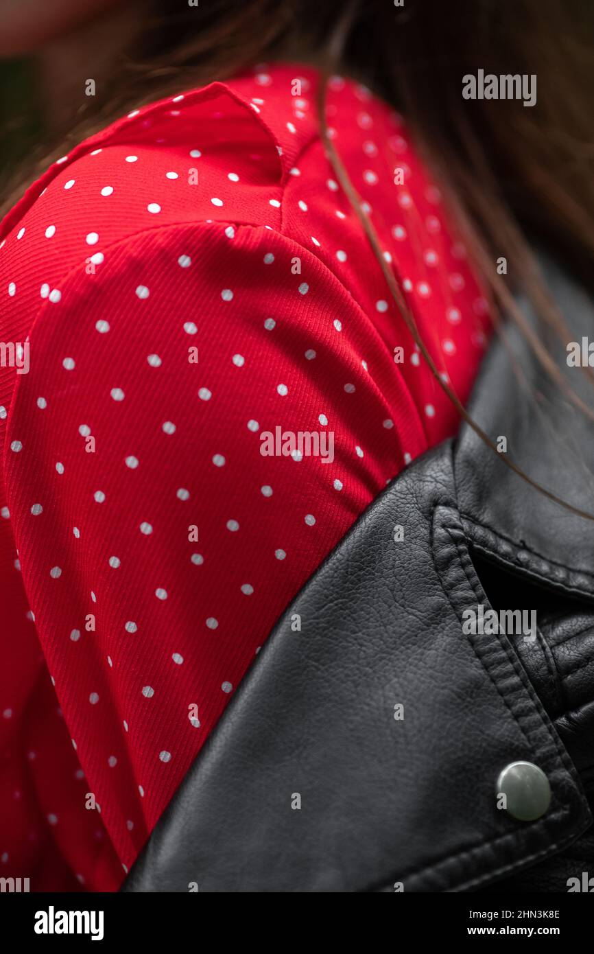 A girl in a light red airy dress, a leather jacket in a rockstyle on an ...