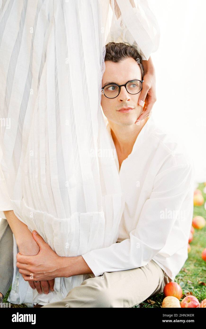 Man sits on the grass hugging the legs of a woman. Close-up Stock Photo ...