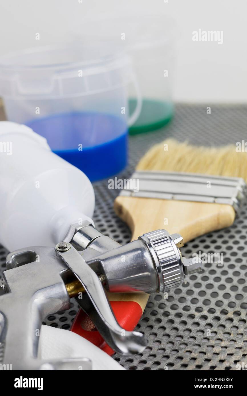 Instructions and a paint spray gun at work at the workplace in the ...