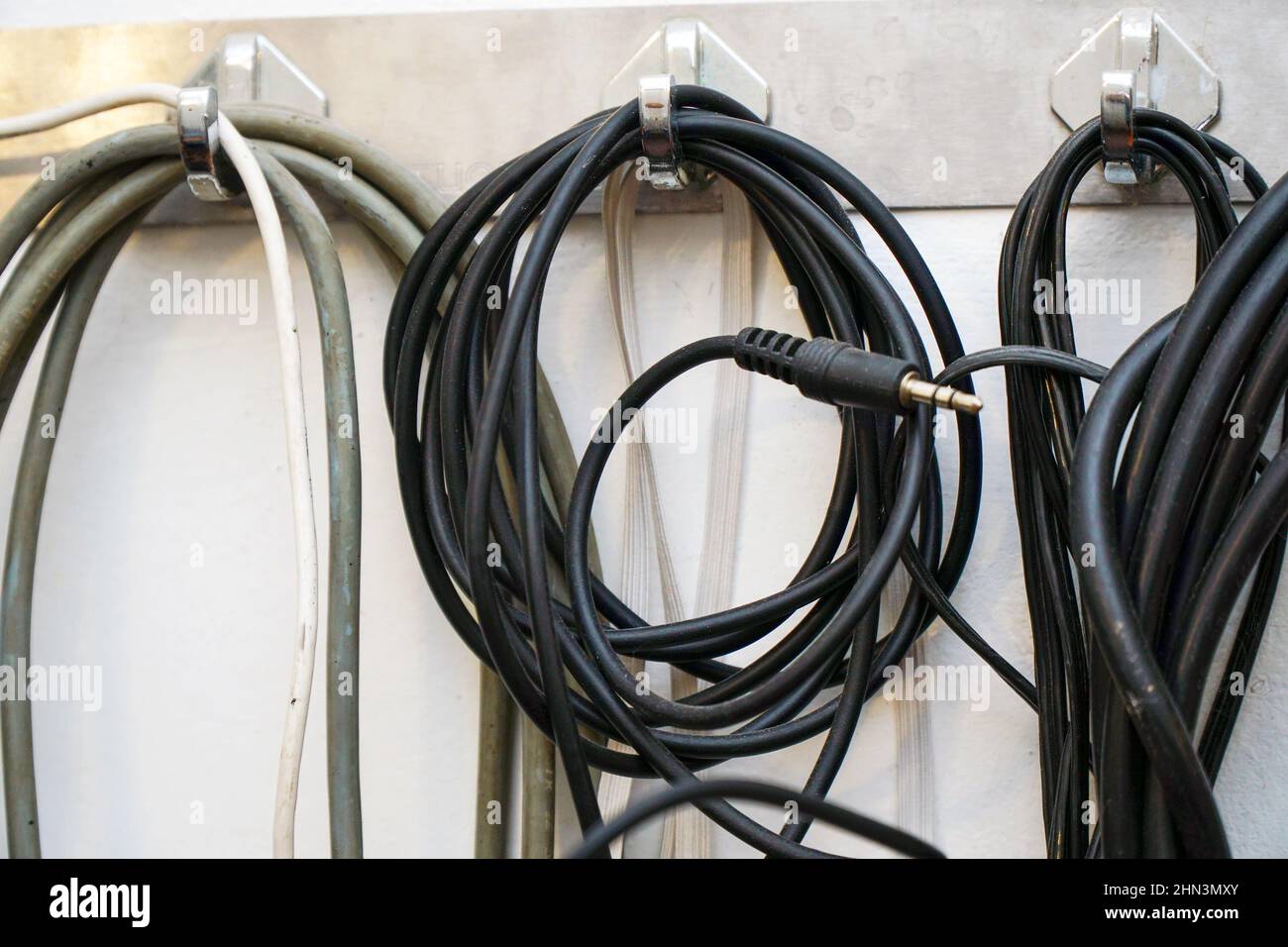Coiled audio cables hang on the wall in the studio Stock Photo - Alamy