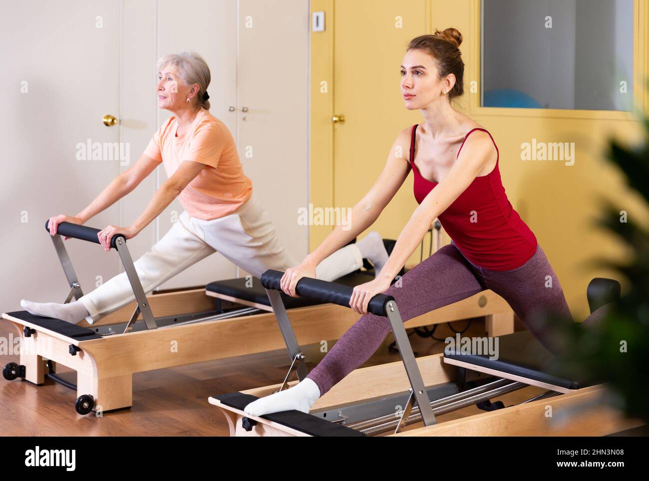 Two active women perform stretching exercises Stock Photo - Alamy
