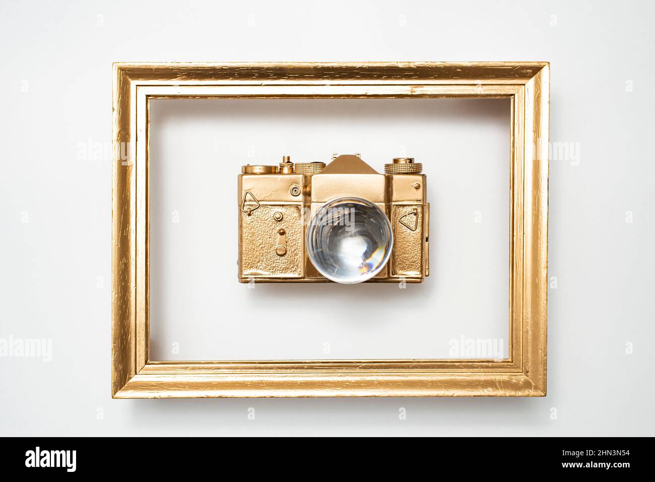 Golden camera in a golden frame, with a lens ball instead of camera ...