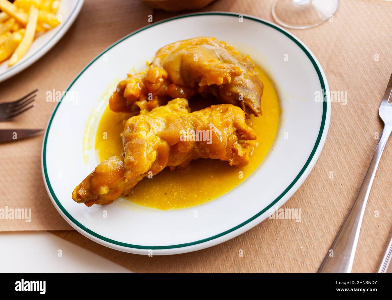 Typical Andalusian stewed pork trotters in gravy Stock Photo - Alamy