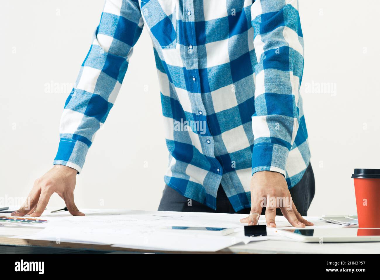 Architect standing near desk with blueprints Stock Photo - Alamy