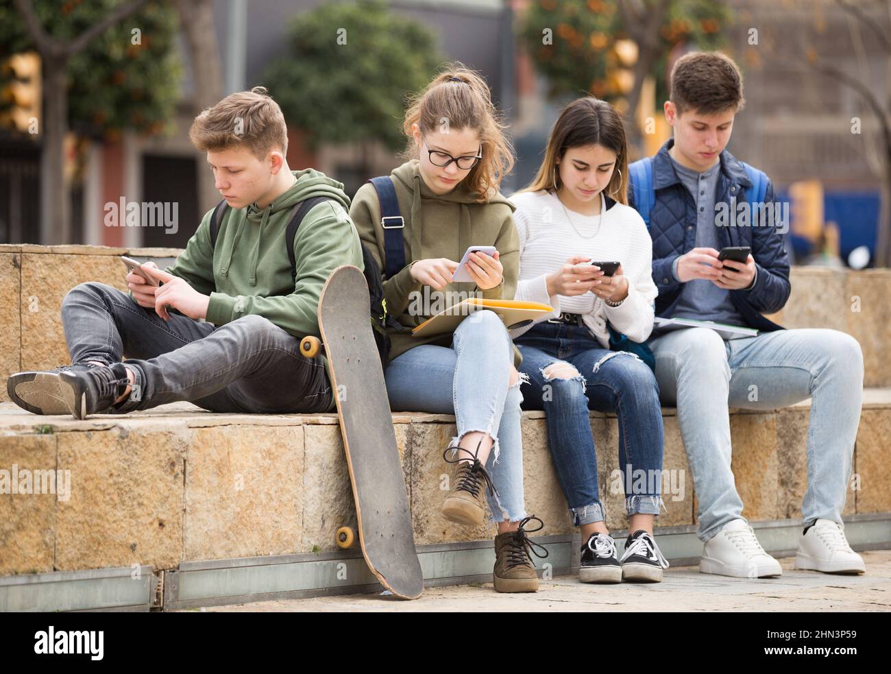 Group of teens using smartphones outdoors Stock Photo - Alamy