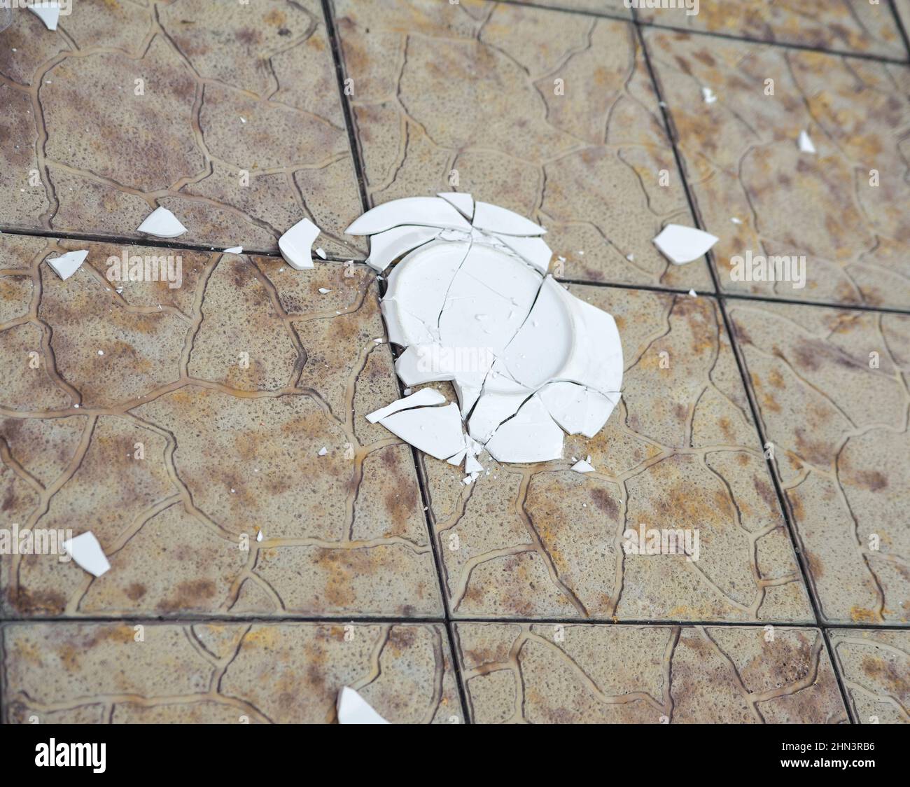 broken plate on a tile background Stock Photo - Alamy