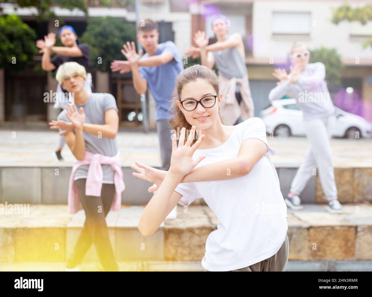 Teen girl dancing modern choreography with group outdoors Stock Photo ...