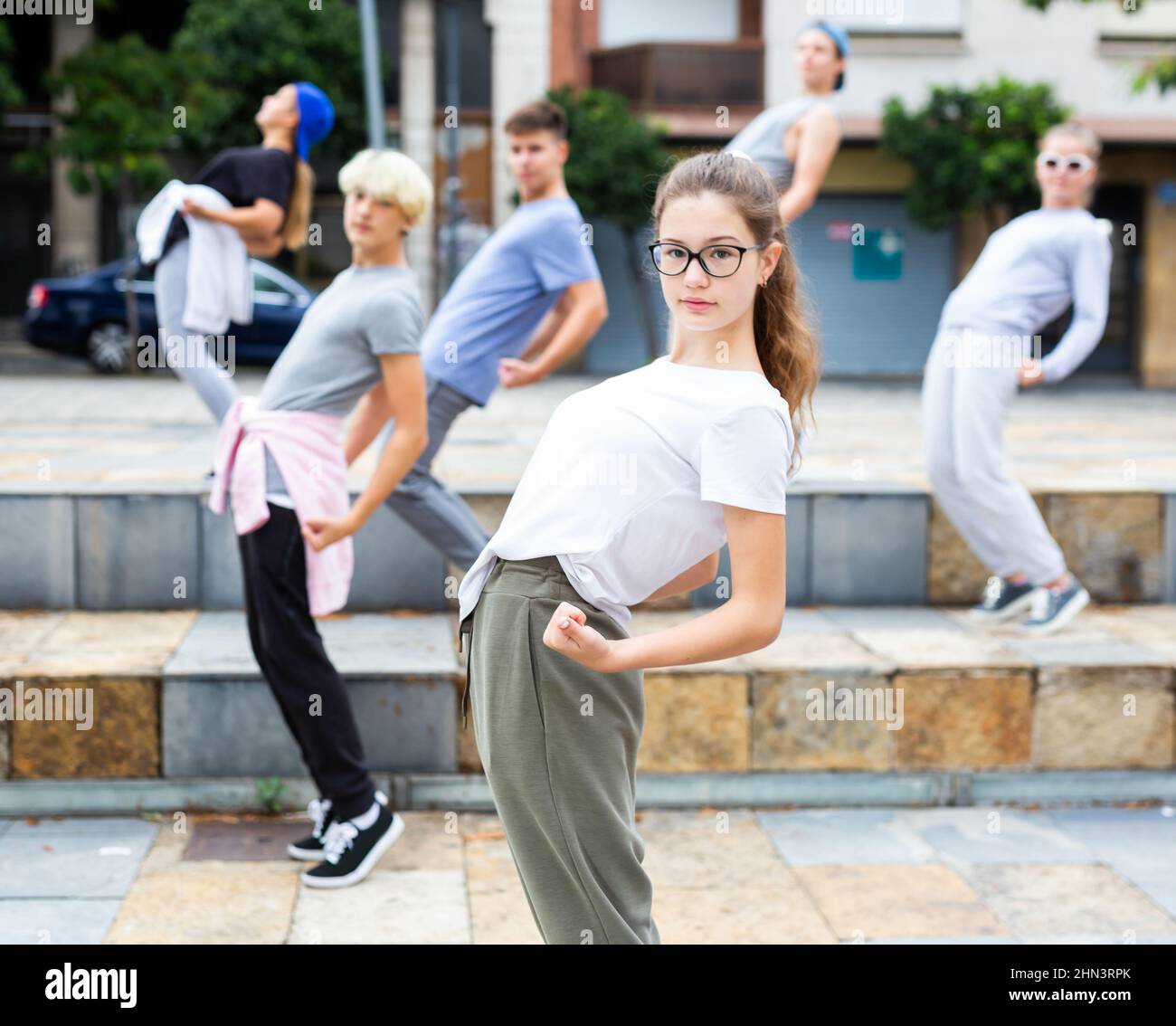 Portrait of emotional girl doing hip hop movements during group class ...