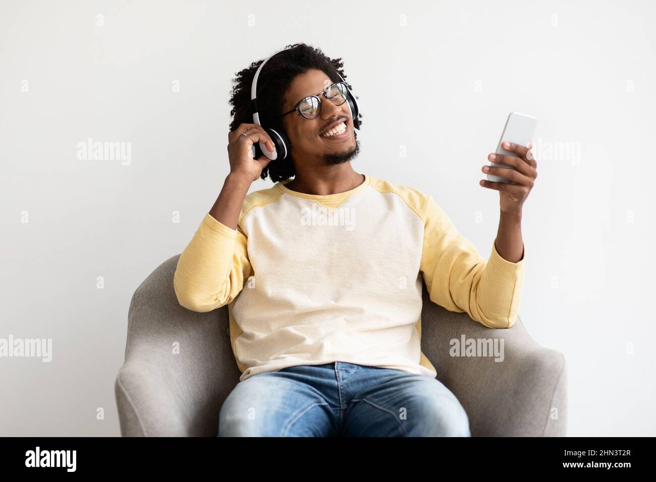Man headphones sitting on armchair hi-res stock photography and images ...