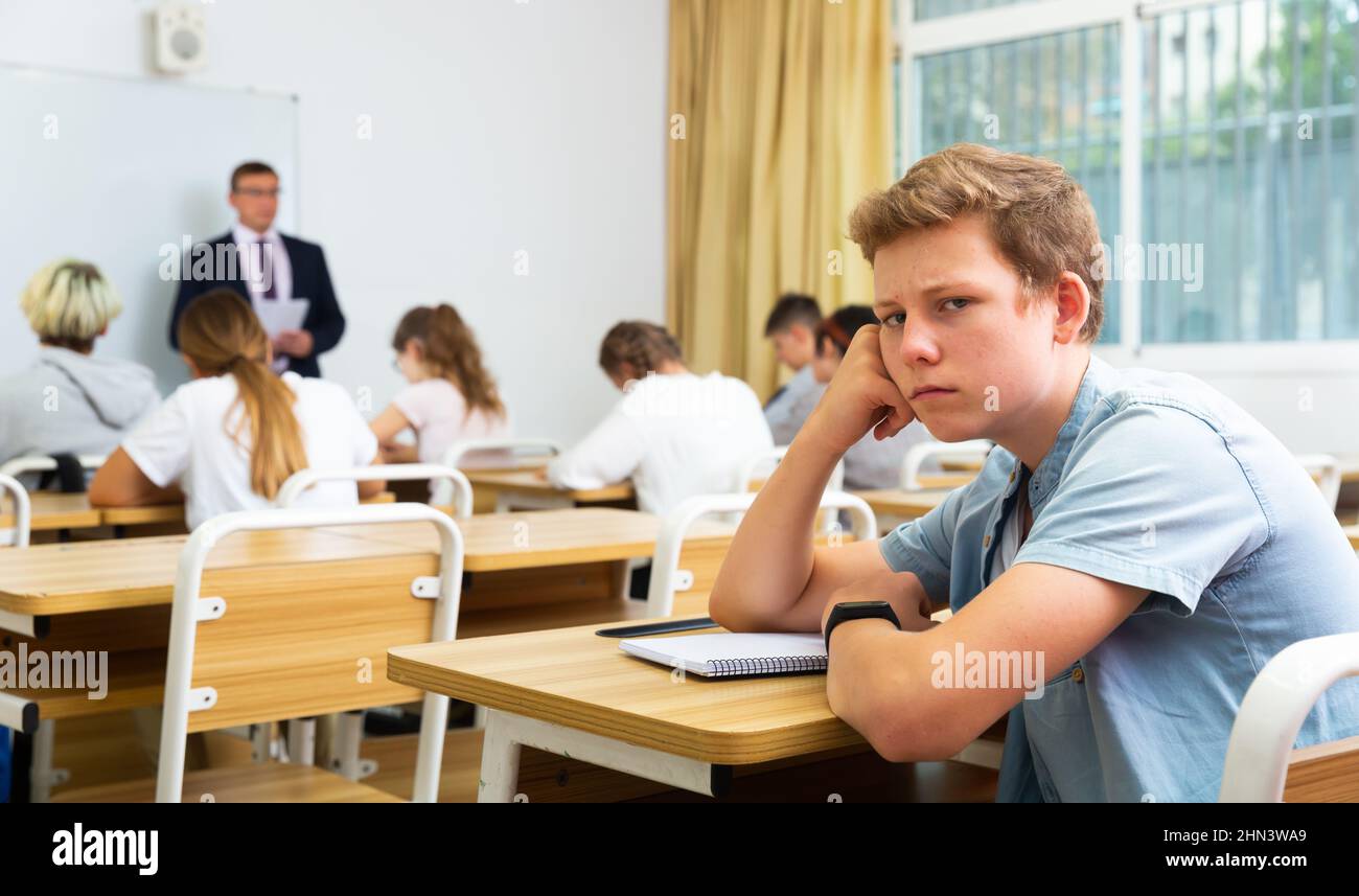 Portrait of disgruntled teenager boy at classroom Stock Photo - Alamy