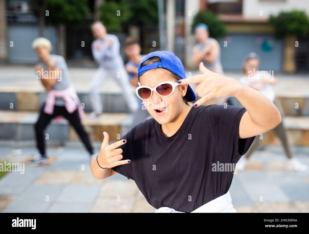 Portrait of emotional girl doing hip hop movements during group class ...
