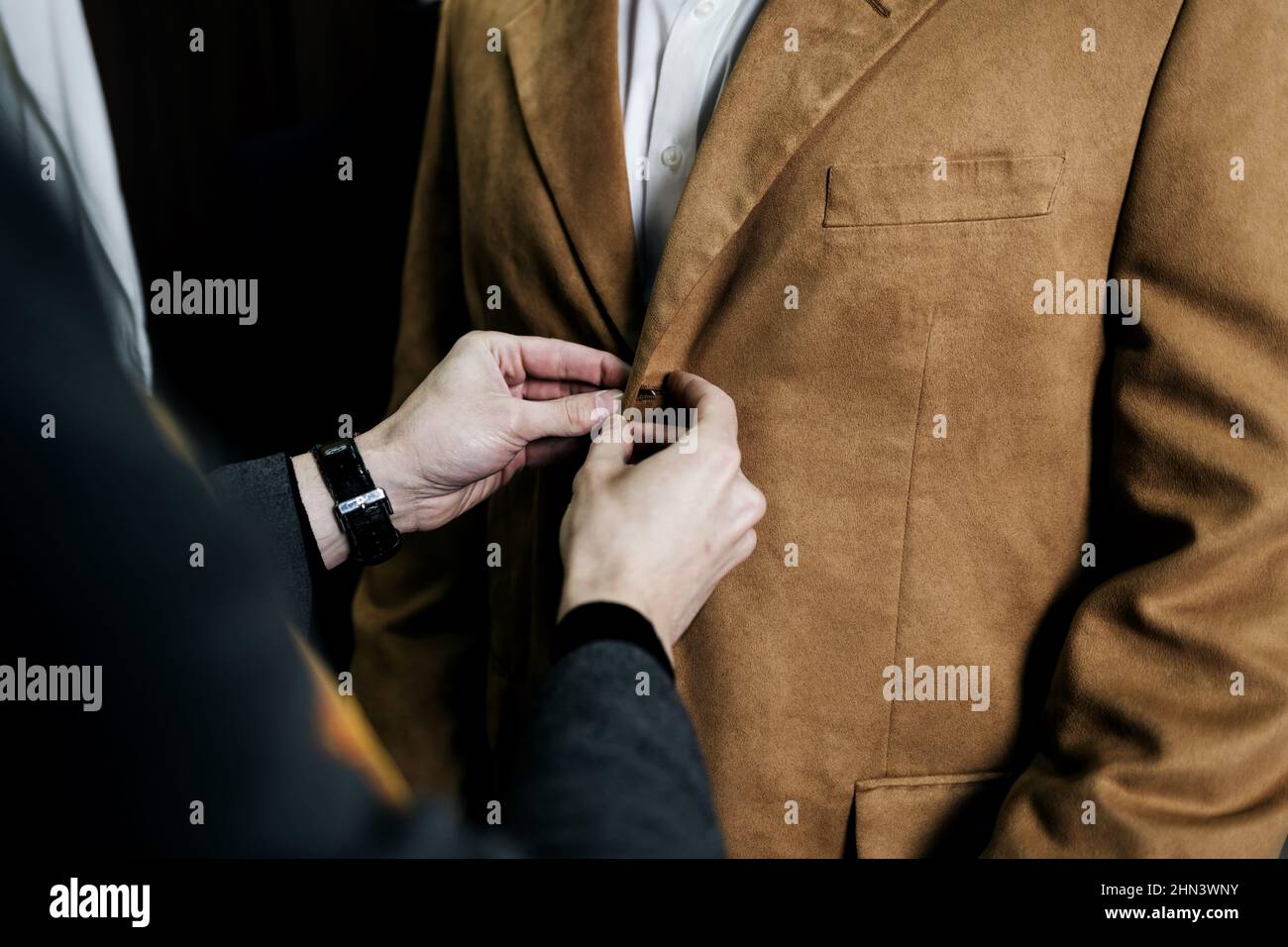 fashion designer fitting bespoke suit to model, close-up shot. male ...