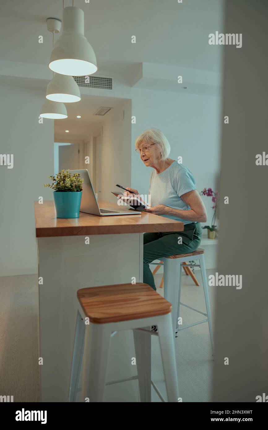 Senior woman sitting home table hi-res stock photography and images - Alamy