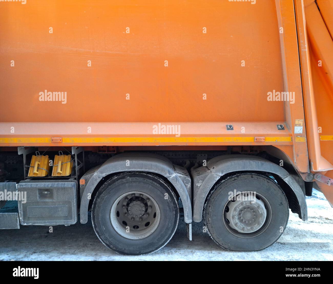 Fragment of a large garbage disposal machine. Orange garbage truck ...