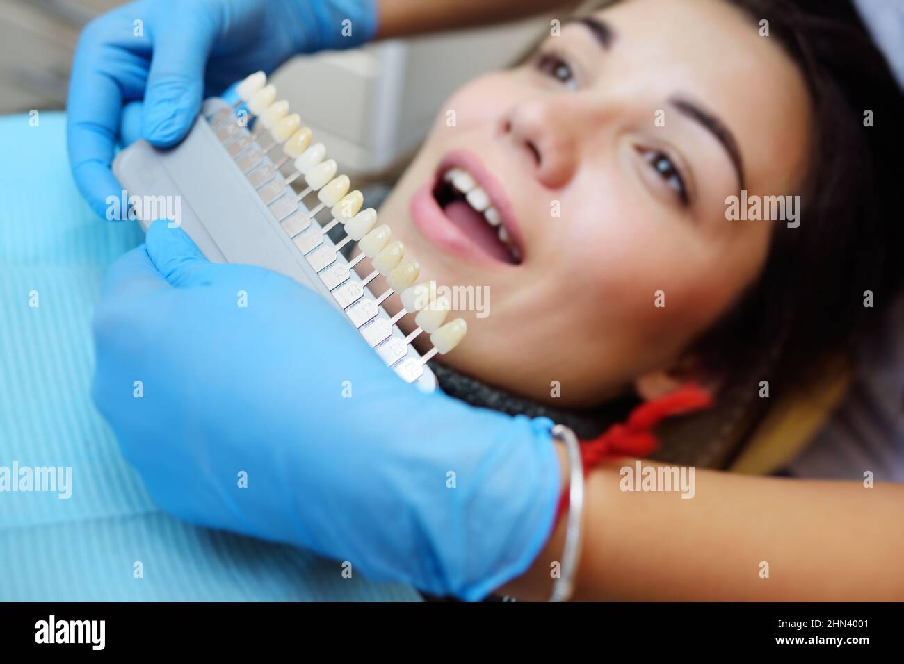 The dentist helps the patient choose a shade of teeth Stock Photo - Alamy