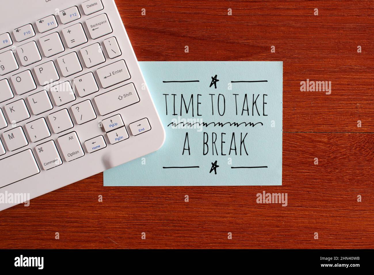 Top view image of keyboard and blue paper with text TIME TO TAKE A ...