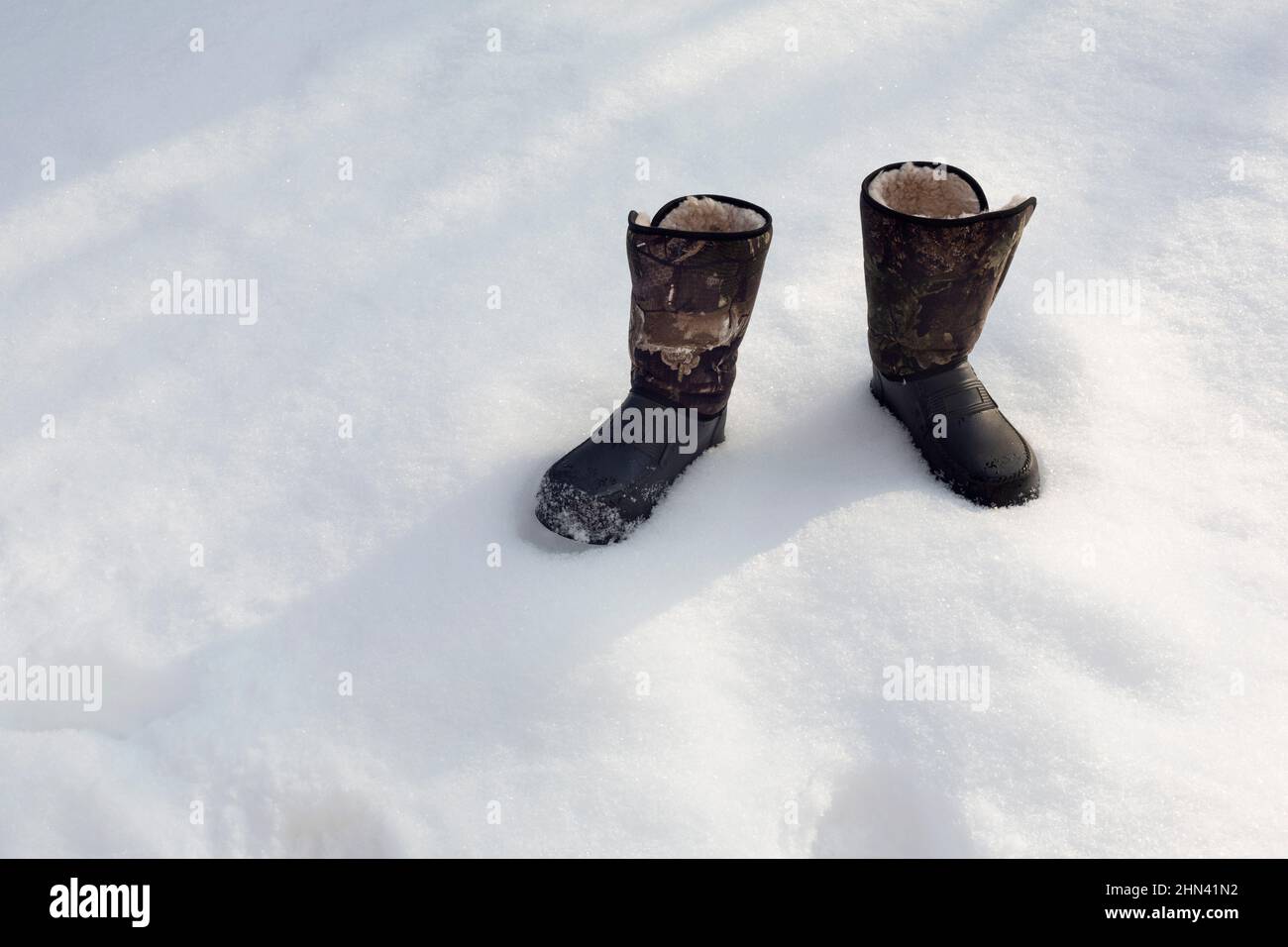 Camouflage winter boots in snow Stock Photo - Alamy