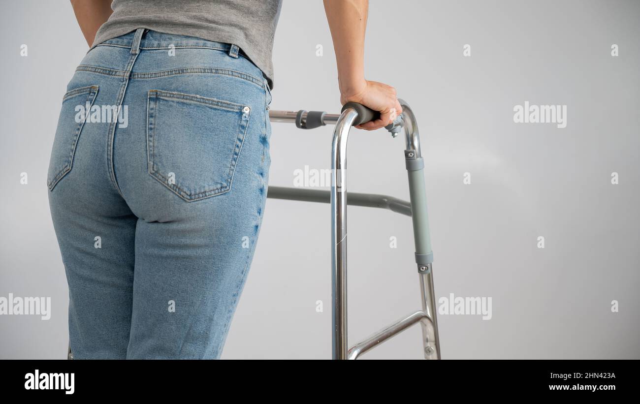 A woman is walking with a walker on a white background Stock Photo - Alamy