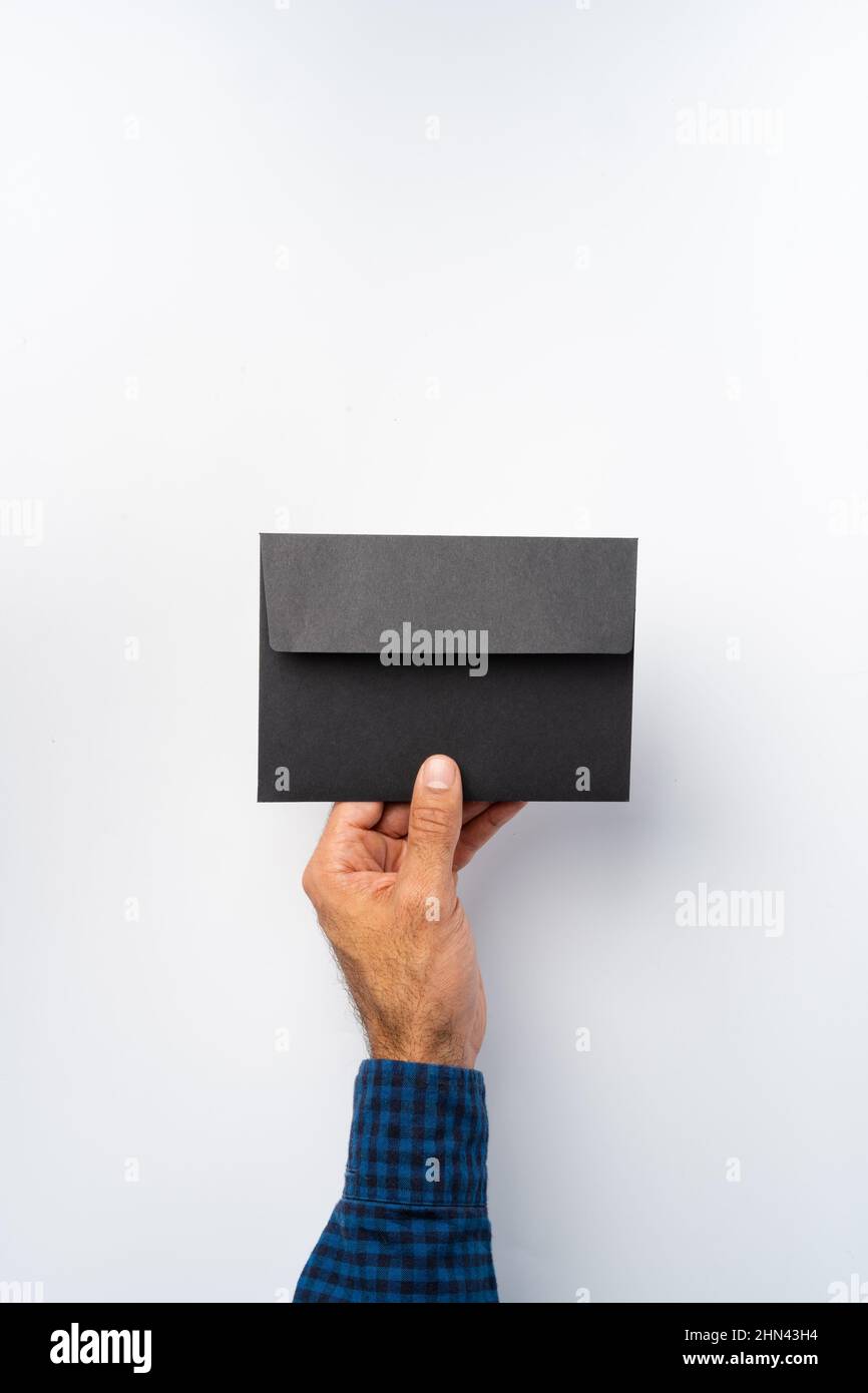 Male hand holding parcel post against white background Stock Photo - Alamy