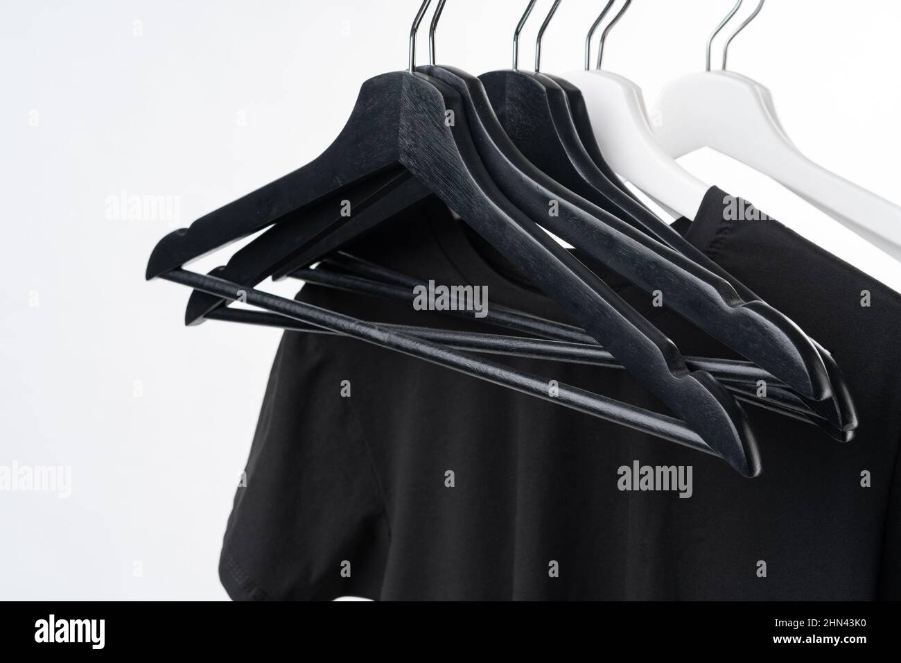 Black T-shirt on hangers on metal rack isolated on white background ...