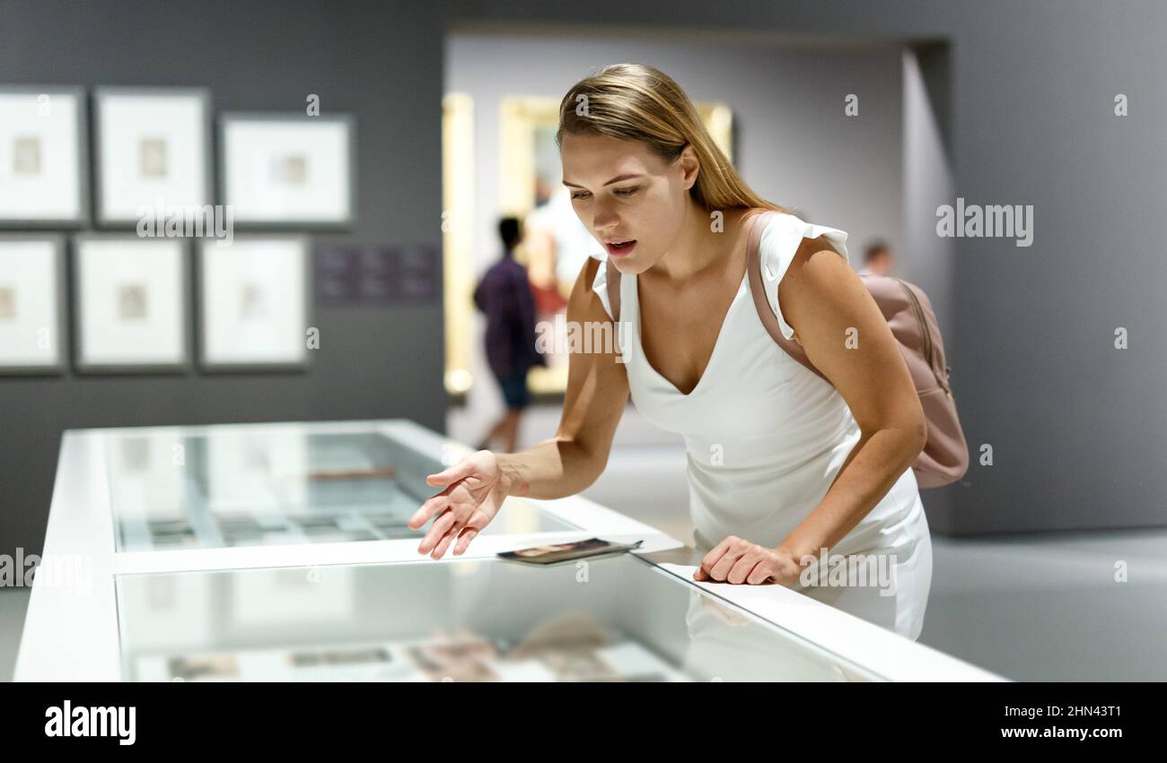 Woman exploring artworks in museum Stock Photo - Alamy