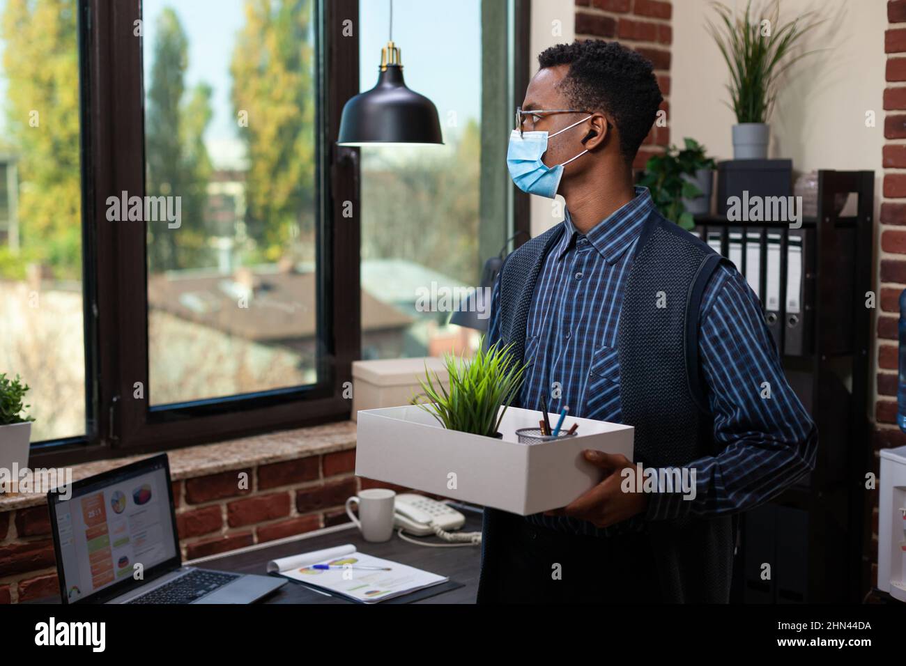African american employee with face mask looking disappointed out the ...