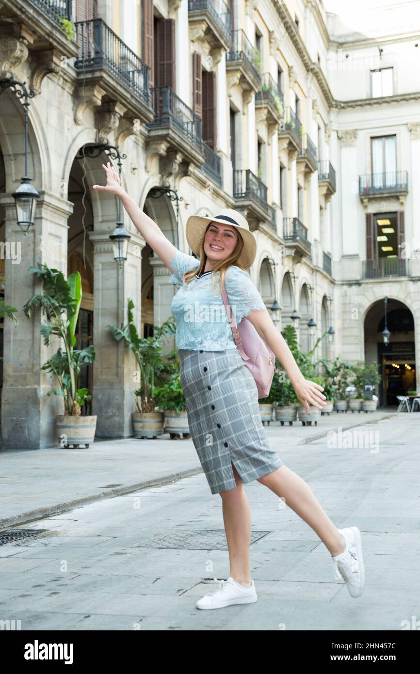 Emotional female in hat glad posing and holding arms to sideward-upward ...