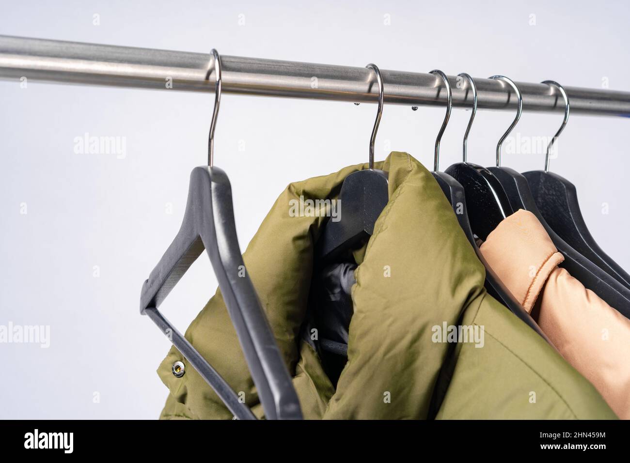 Clothes hang on clothing rack over white background Stock Photo - Alamy