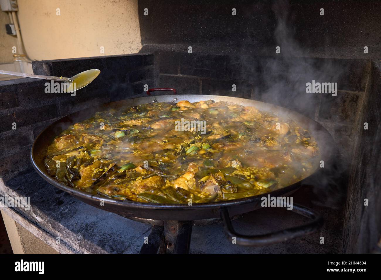 coocking traditional Valencian paella outdoors. Kitchen with gas ...