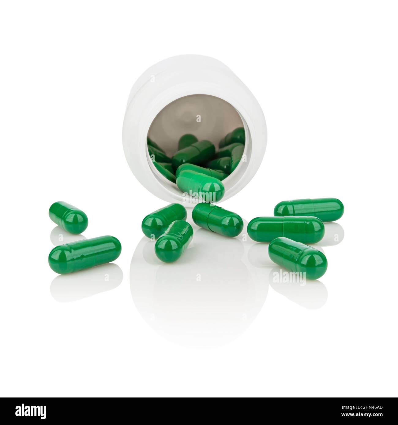 Green medicine capsules pouring from a pill bottle. isolated on white ...