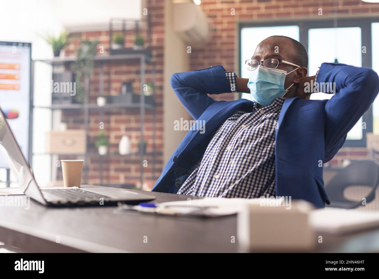 Employee relaxing at desk after finishing business project task during ...