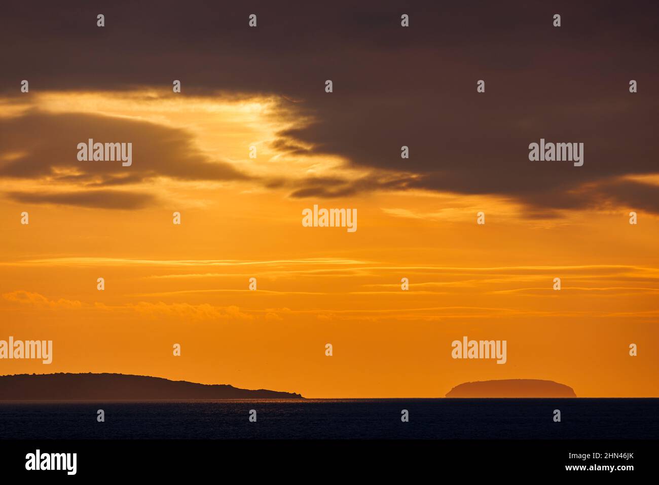 The setting sun lighting up the horizon Stock Photo - Alamy