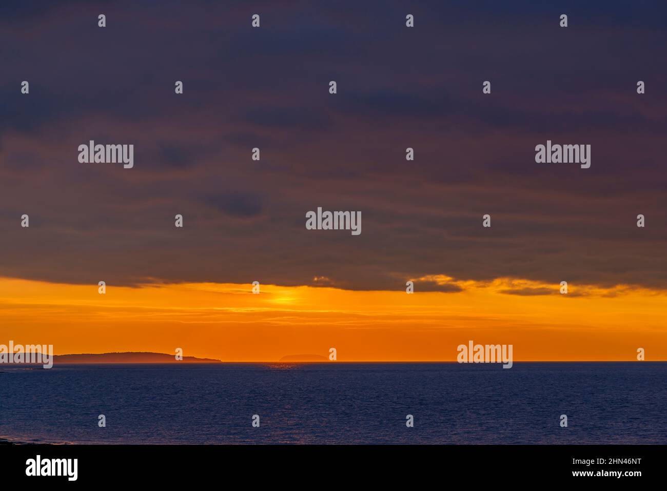 The setting sun lighting up the horizon Stock Photo - Alamy