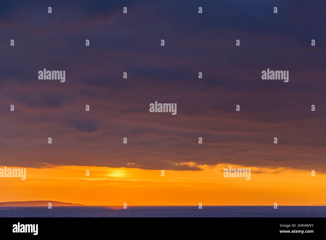 The setting sun lighting up the horizon Stock Photo - Alamy