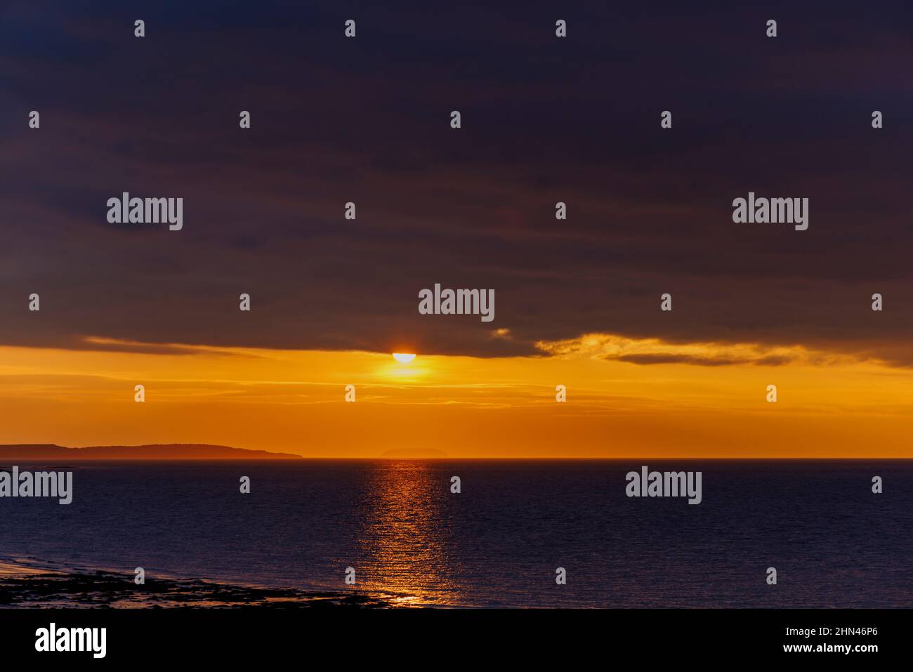 The setting sun lighting up the horizon Stock Photo - Alamy