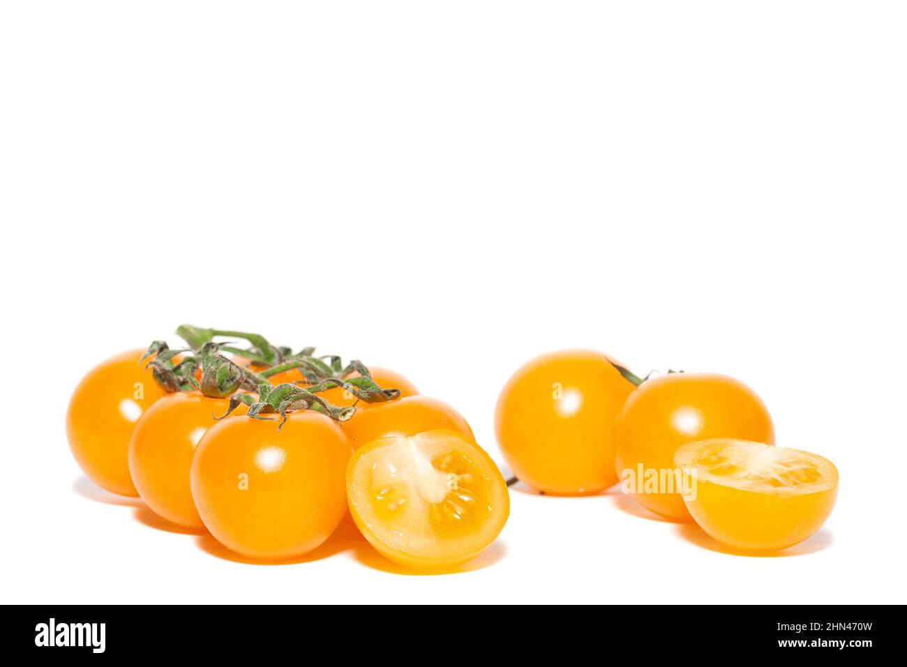 fresh yellow "tasty tom" tomatoes on the vine on a white background ...