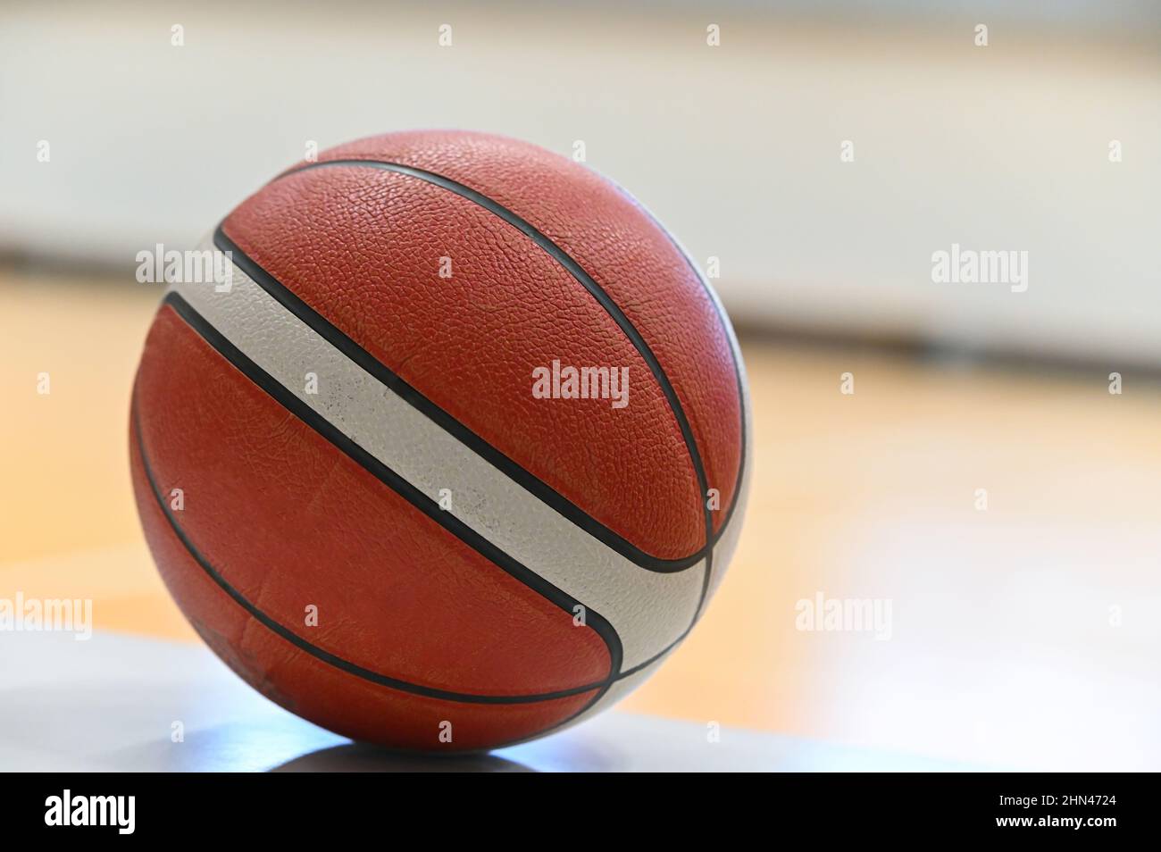 Basketball on a white table with a basketball court in the background ...