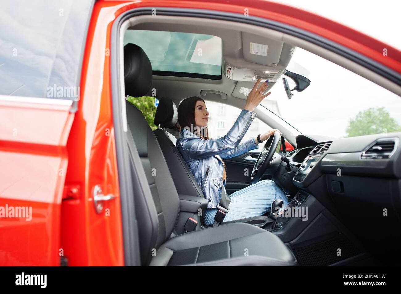 Gorgeous woman sitting inside car with open door Stock Photo - Alamy